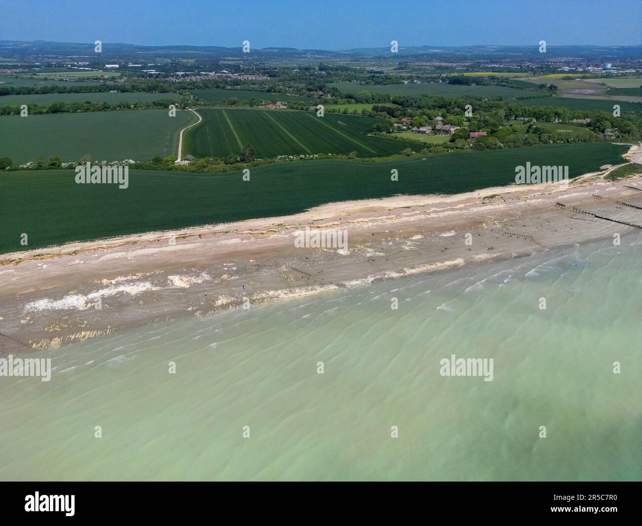 An Aerial photo of a lush green grassy field with a beach shoreline in ...