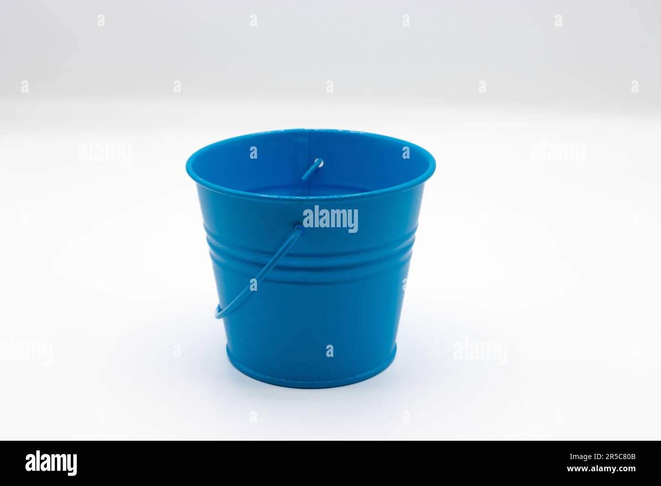 Blue metal miniature bucket on white background Stock Photo - Alamy