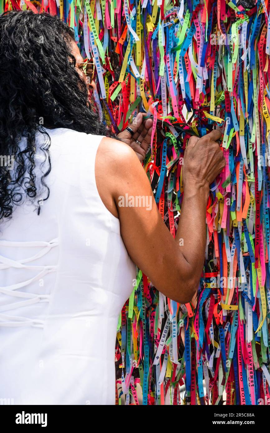 A female artist adorning a wall with colorful ribbons creating an ...