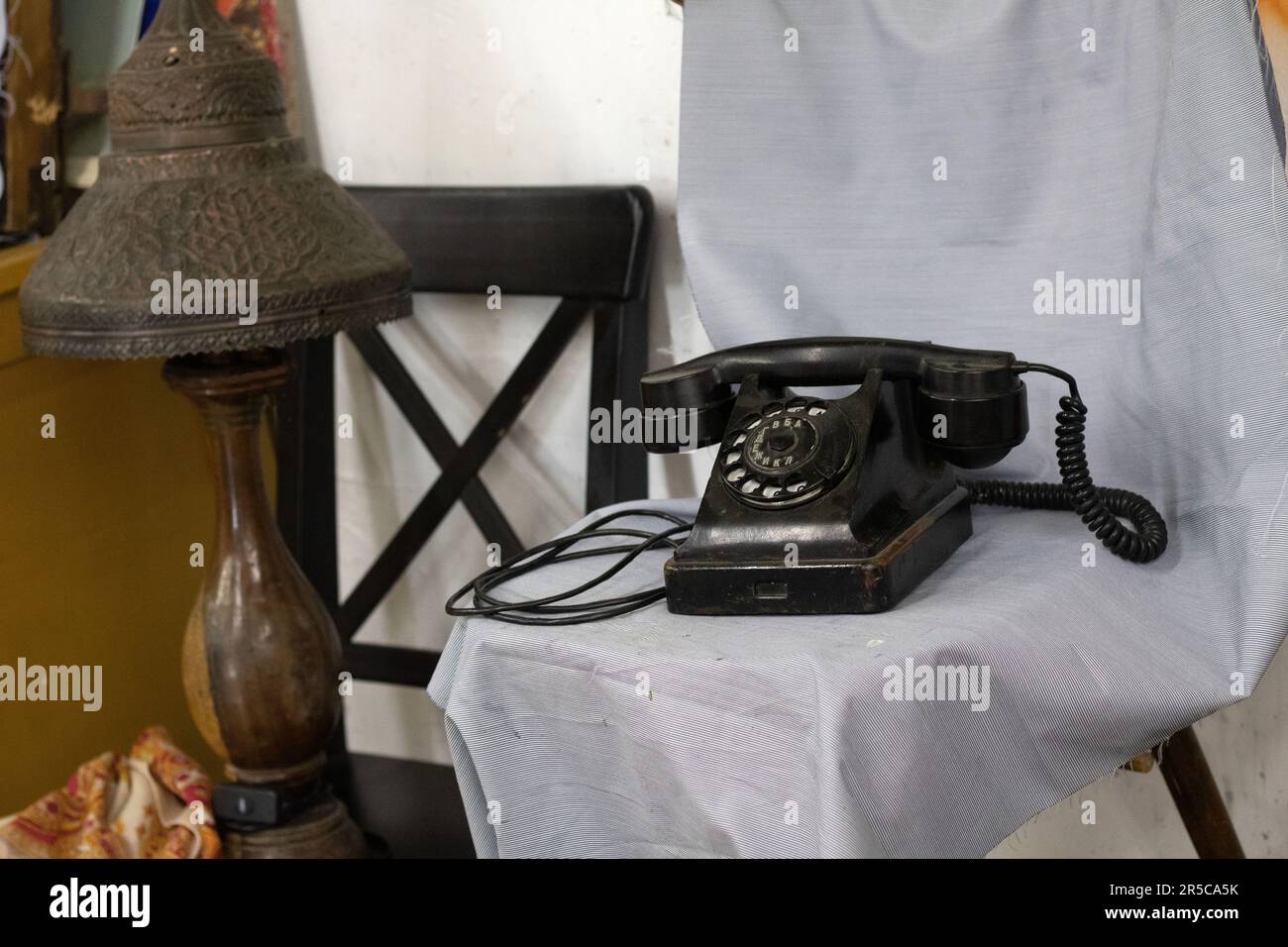 photo of an old phone standing on a chair against a light background ...