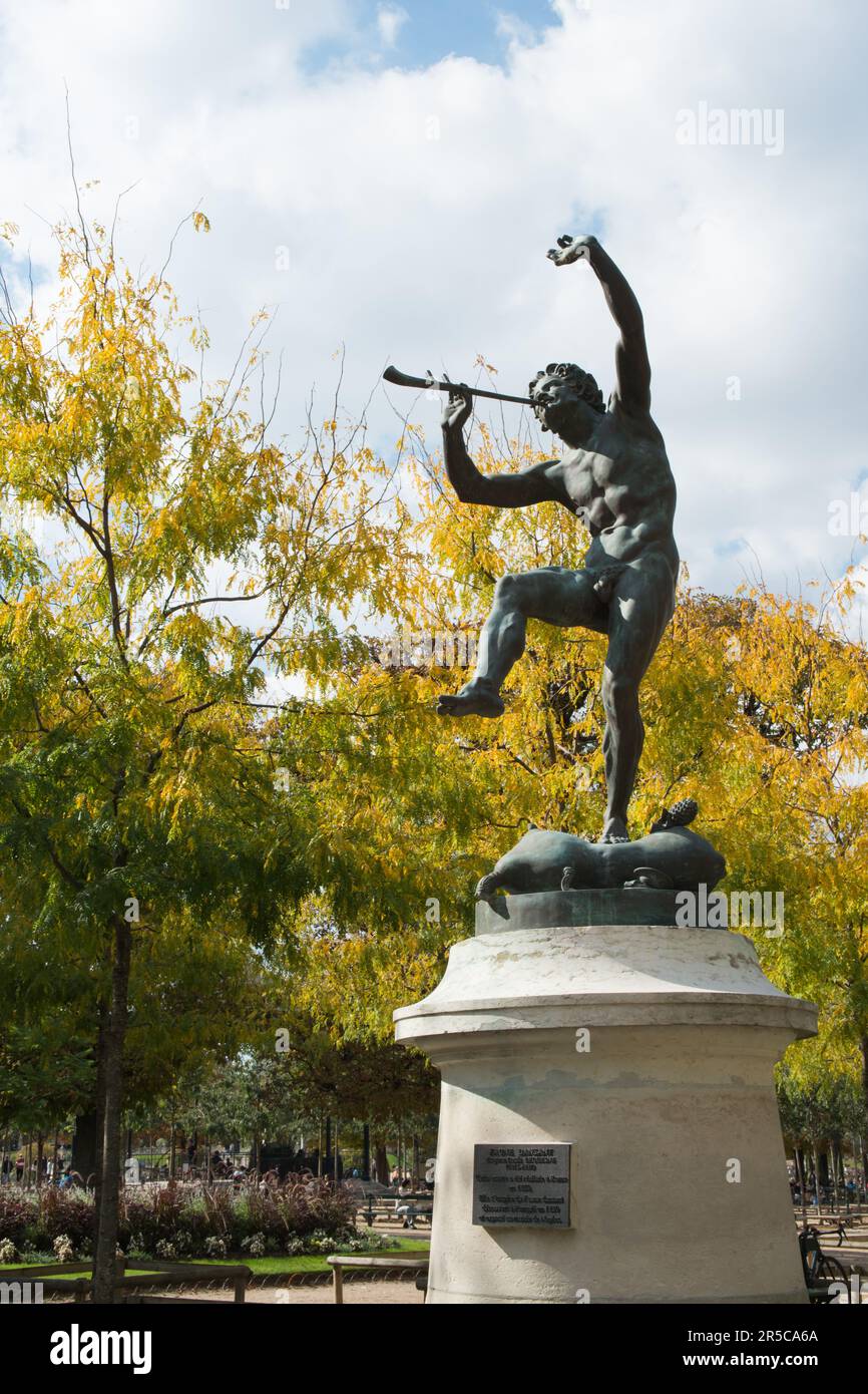 A vertical shot of a sculpture with a man playing the flute in Paris ...