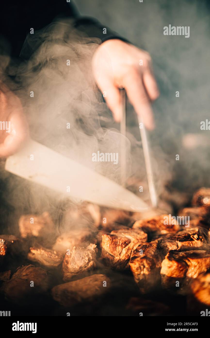 A man grilling food on a barbecue in a backyard settin Stock Photo - Alamy