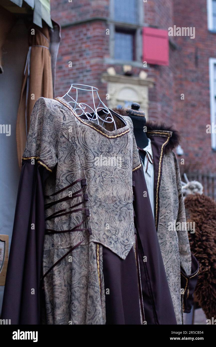 An array of colorful coats hung up on a wall-mounted coat rack in a ...