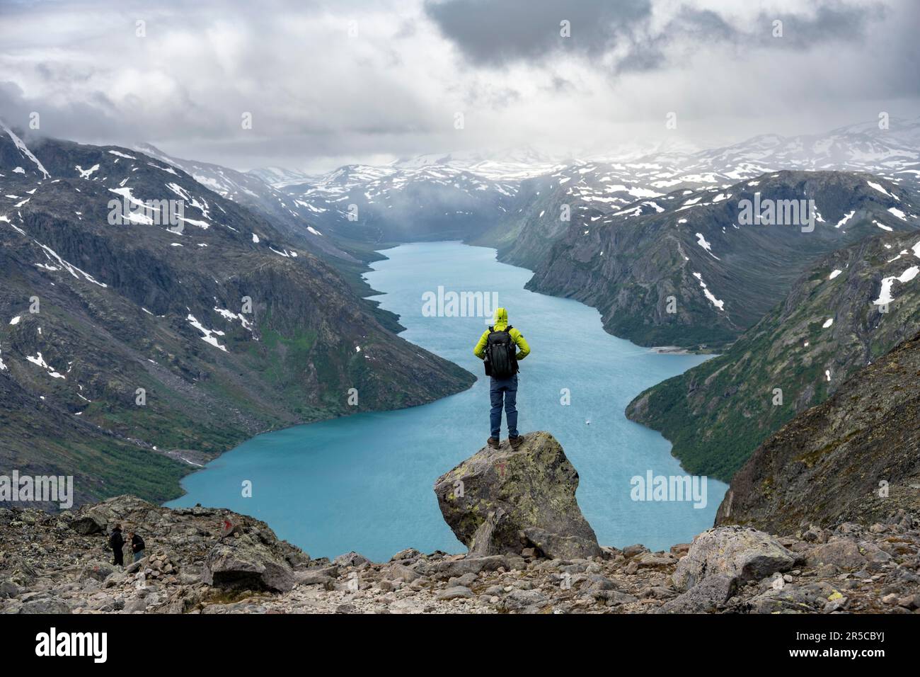 Climber standing on rocks, Besseggen hike, ridge walk, view of Lake ...