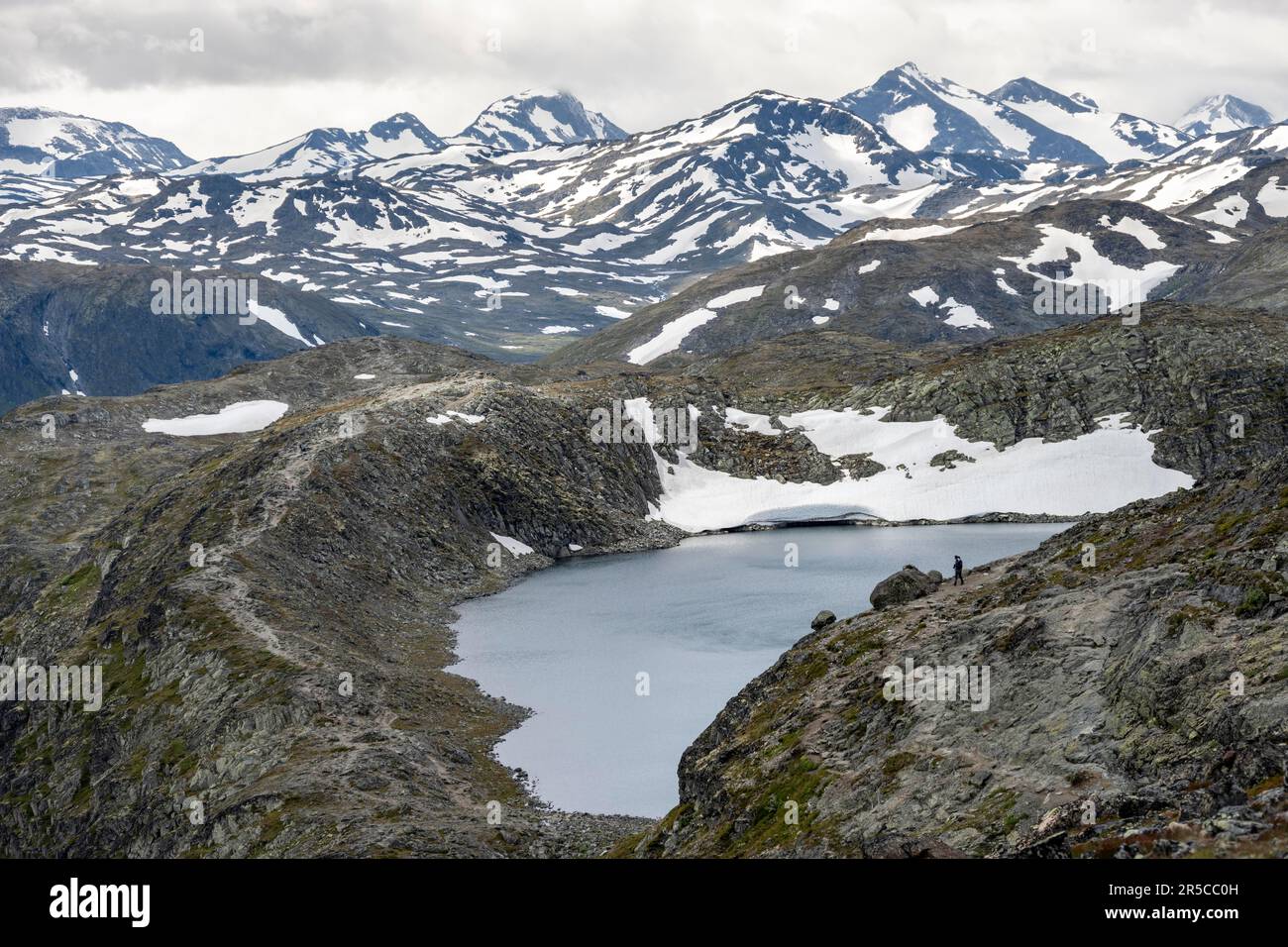 Snowy mountain peaks and lake Bjornboltjonne, Besseggen hike, ridge ...