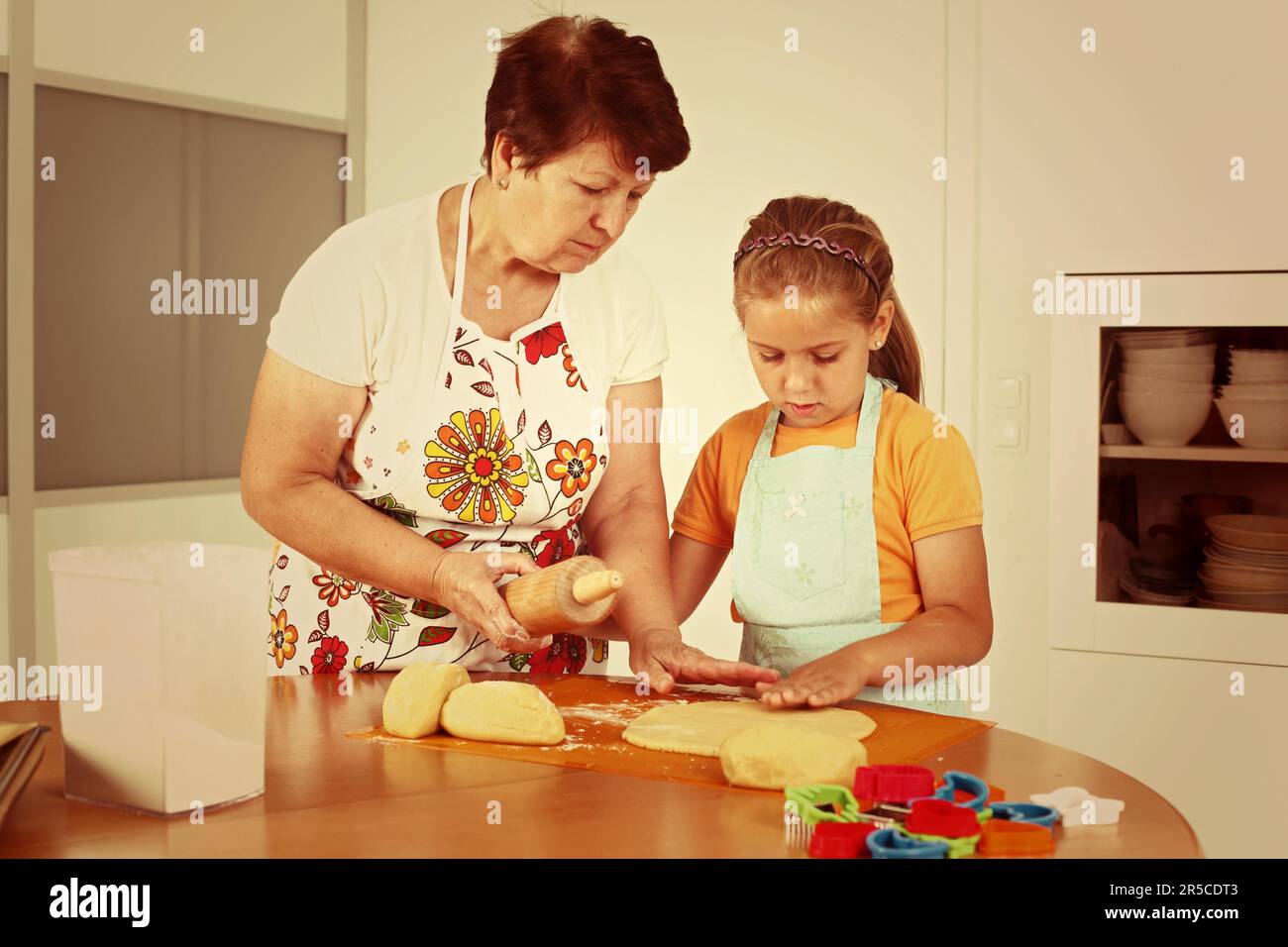 Child and senior woman baking cookies for Christmas in vintage look ...