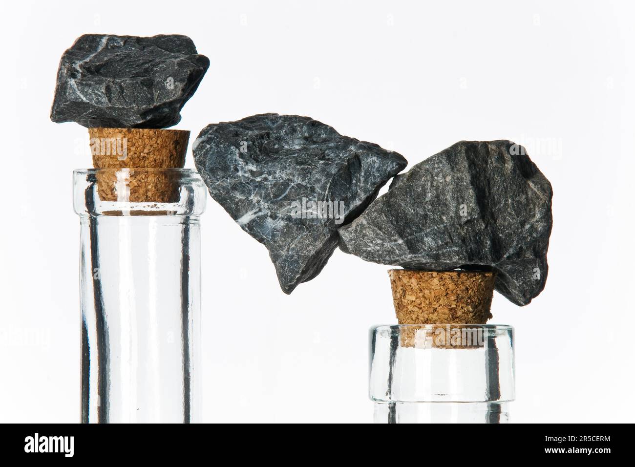 Stones in balance on glass bottles with corks Stock Photo - Alamy
