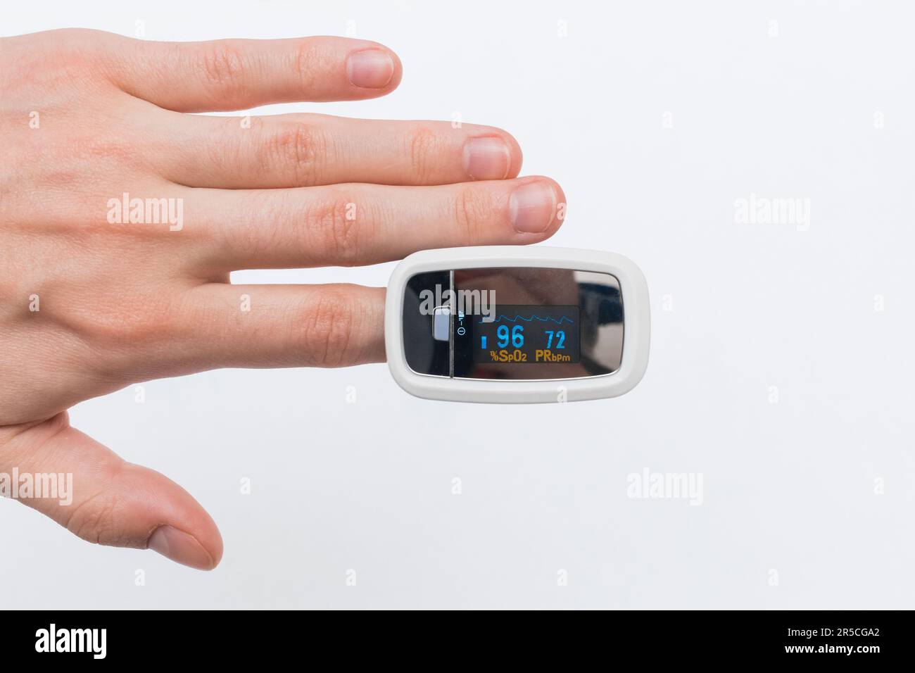 Pulse oximeter on the finger of the young guy's hand medical device to ...