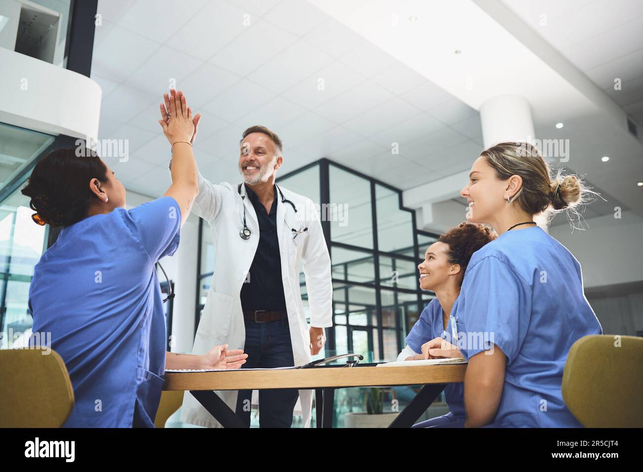 Improving healthcare outcomes together. a team of doctors giving each ...