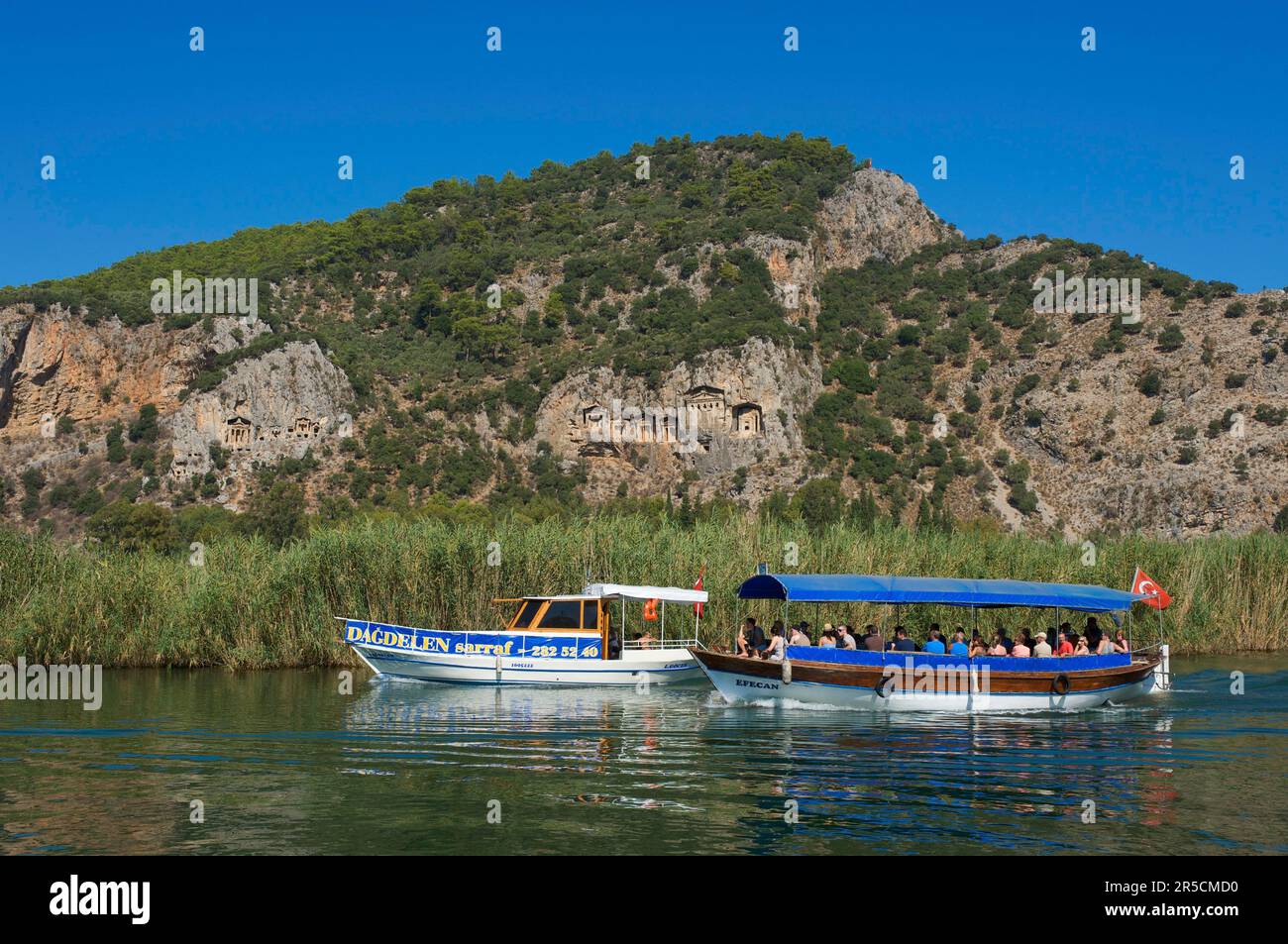 Excursion boats on the Dalyan River in front of the rock tombs of ...