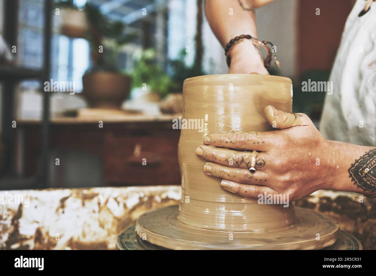 What a marvellous muddy mess. an unrecognisable woman working with clay ...