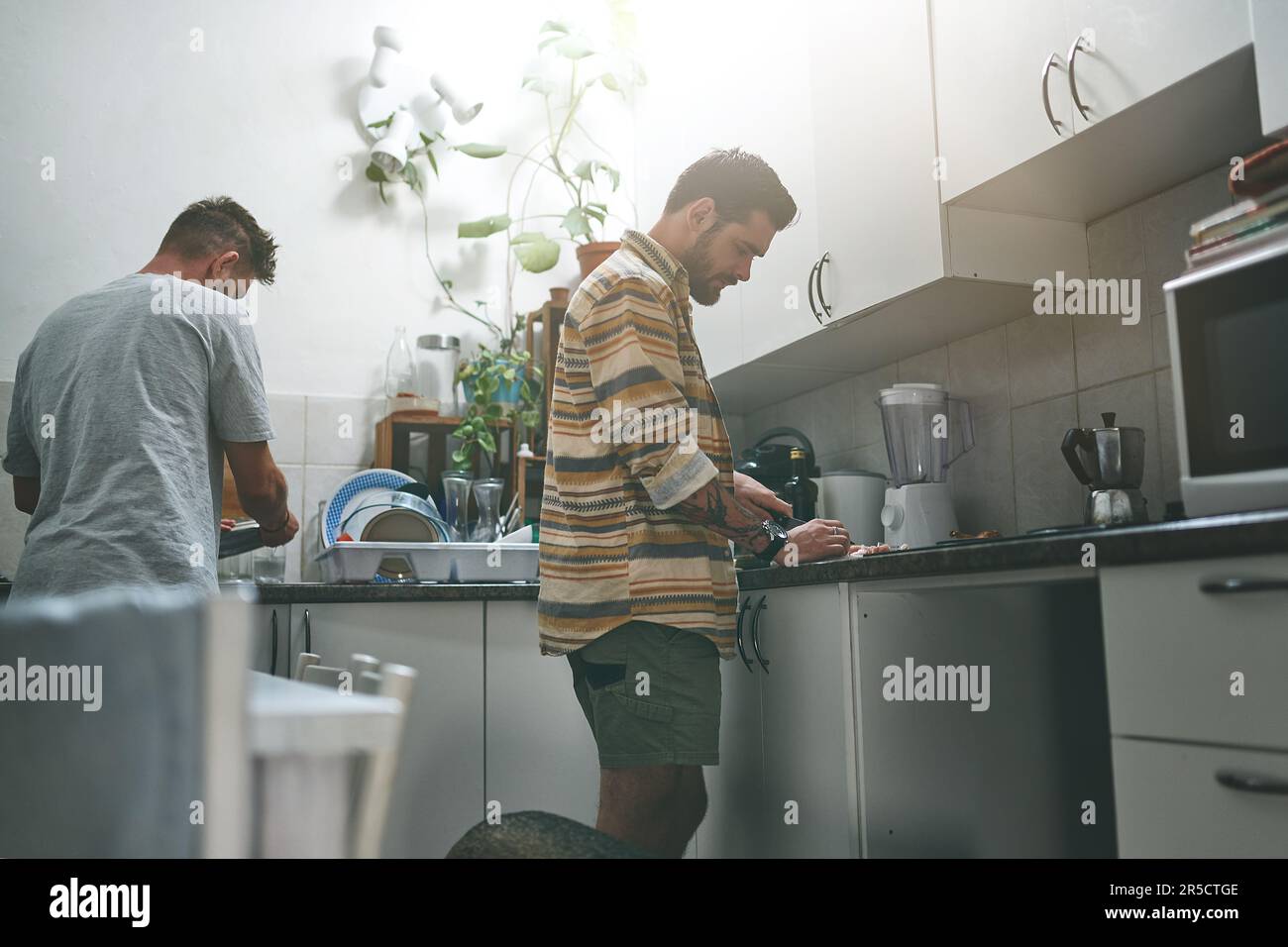 Cooking up something good. two young men making food together in the ...