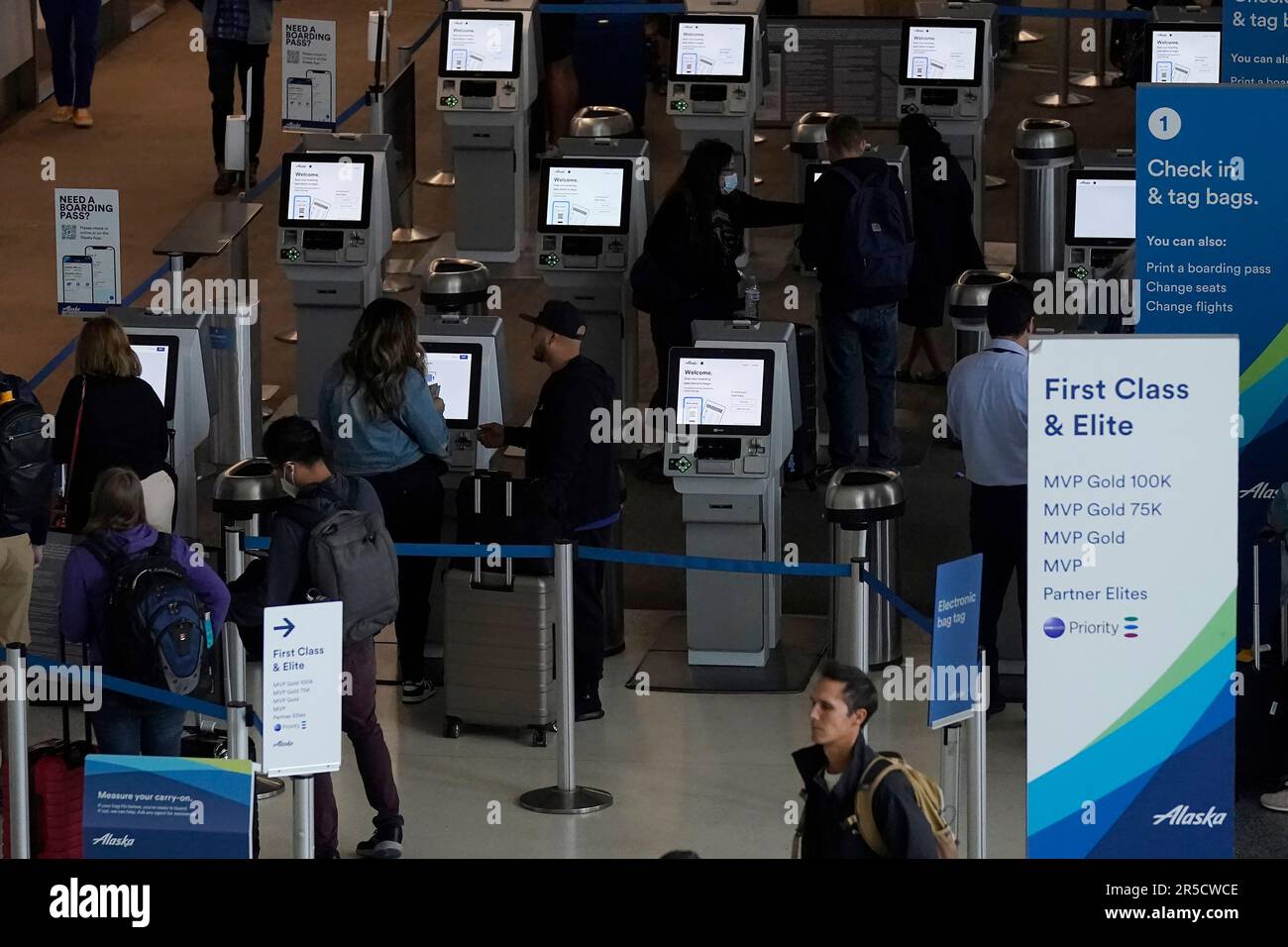 Travelers check in at Alaska Airlines kiosks in the domestic terminal ...