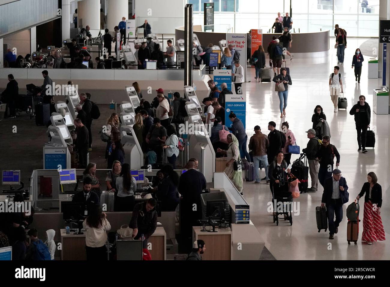 Travelers check in at the American Airlines desk and kiosks in the ...