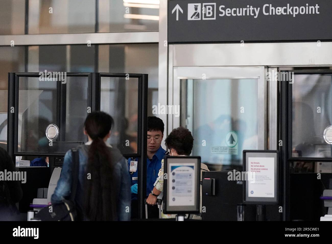 A Travel Security Administration agent checks in travelers in the ...