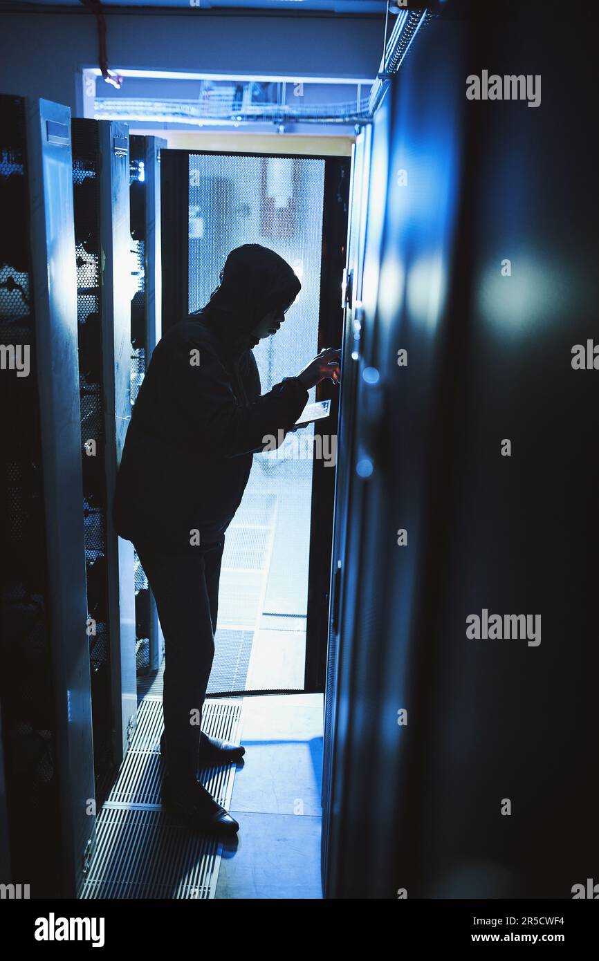 Beware of thieves in the night. a hacker using a digital tablet in a ...