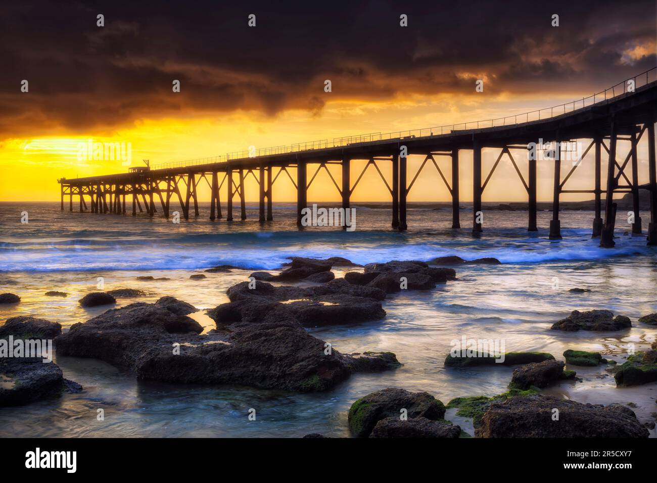 Colourful seascape sunrise at historic timber jetty of Middle Camp ...