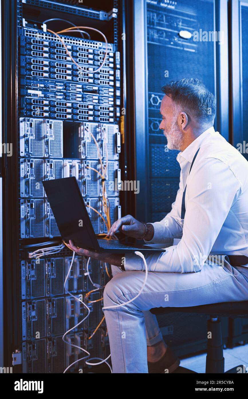 Ensuring all machines are upgraded to standard. a mature man using a ...