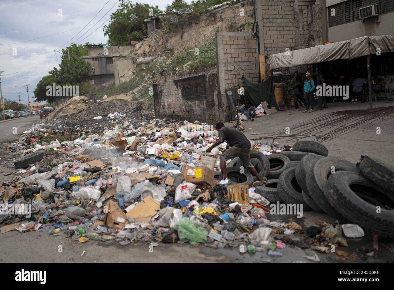 A man walks over accumulated garbage in Port-au-Prince, Haiti, Friday ...