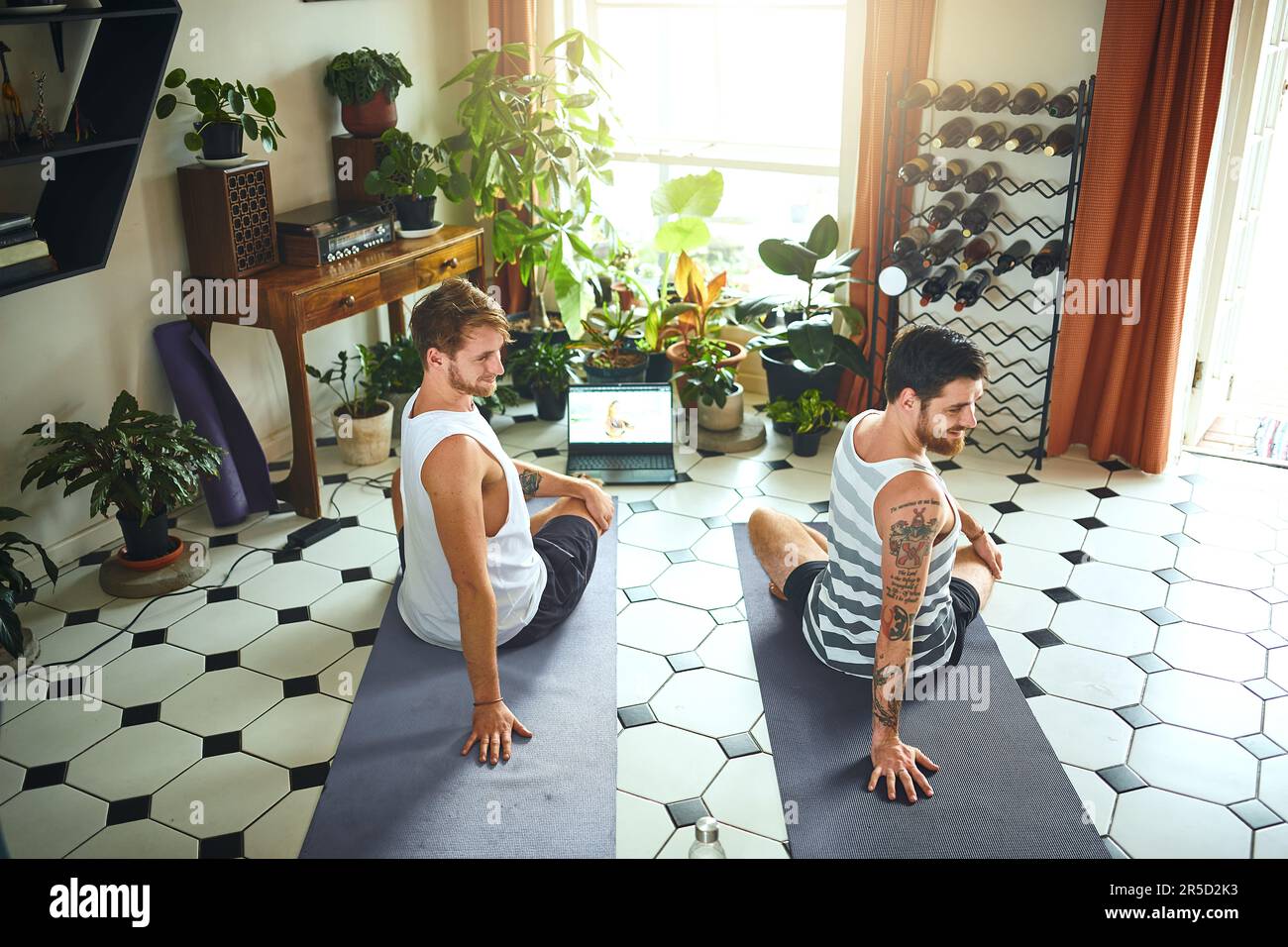 Yoga class with a bit of a twist. two men using a laptop while going ...