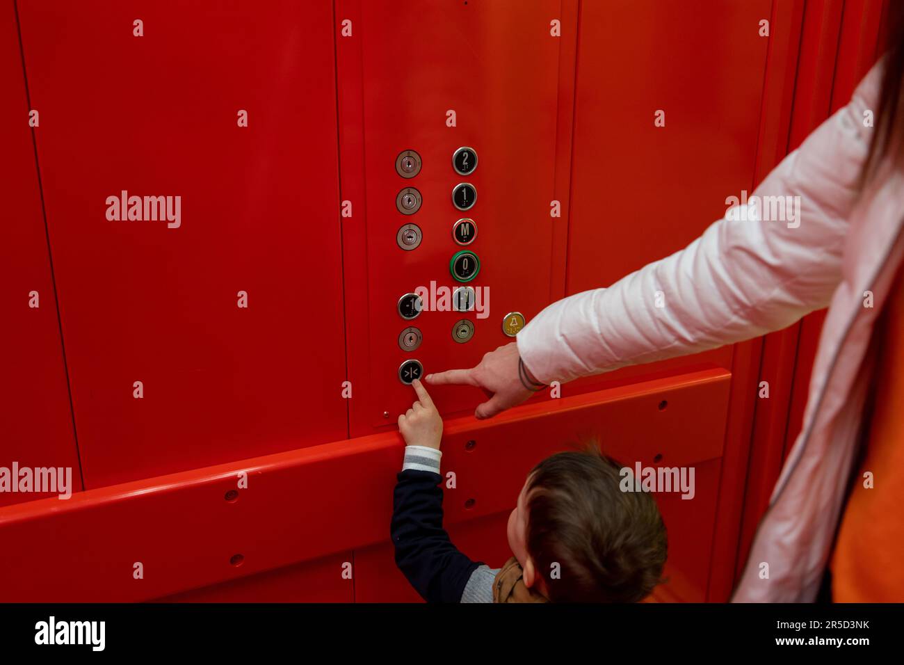 small boy pressing button in red elevator Stock Photo - Alamy
