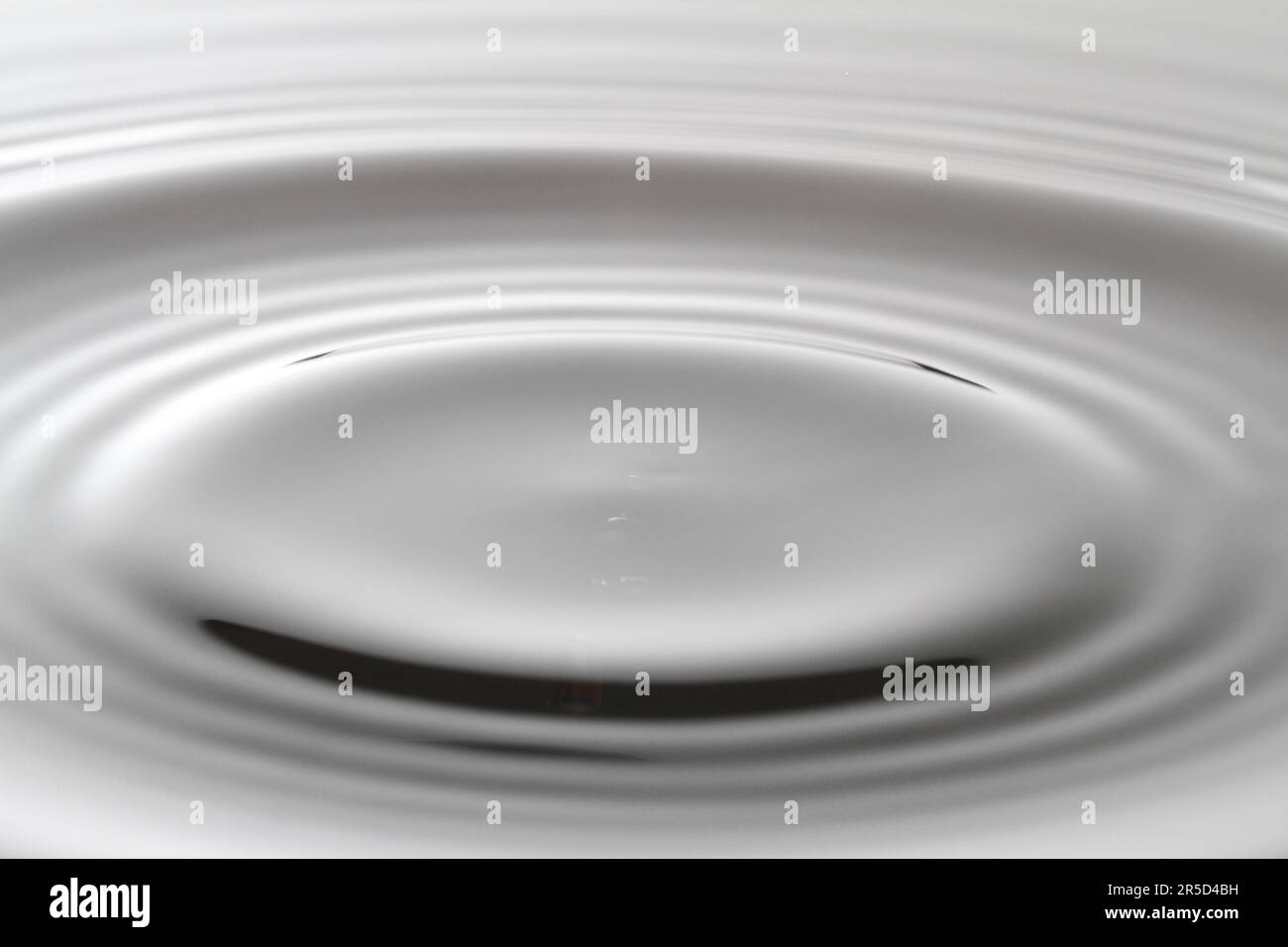 Beautiful water drops splashing on still water Stock Photo - Alamy