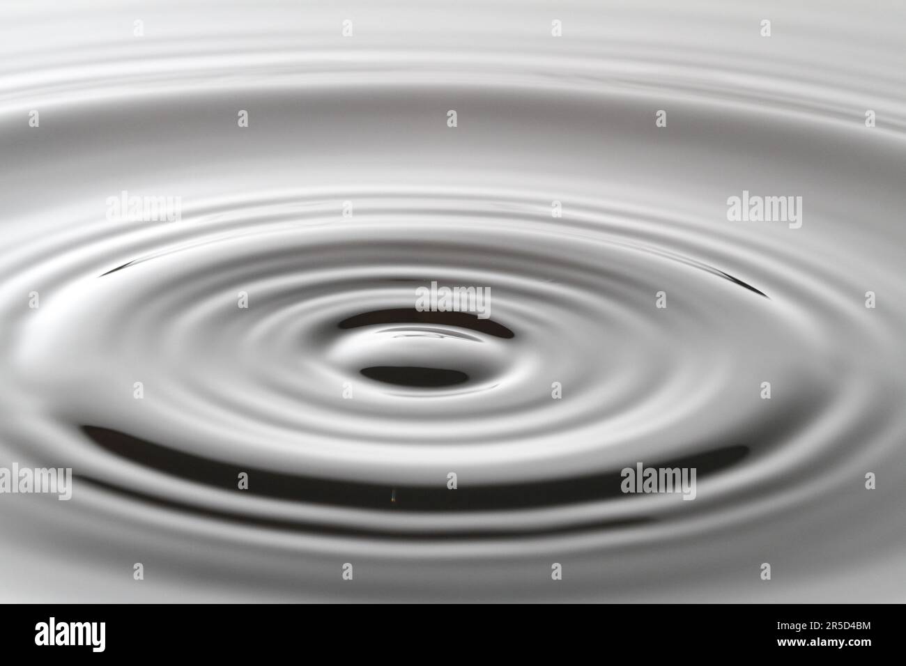 Beautiful water drops splashing on still water Stock Photo - Alamy