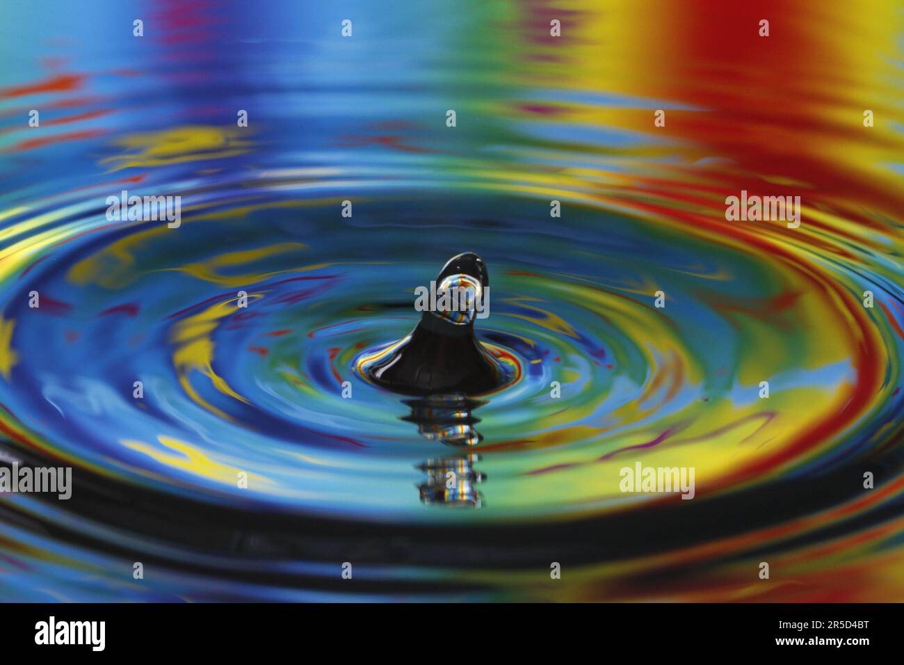 Beautiful water drops splashing on still water Stock Photo - Alamy