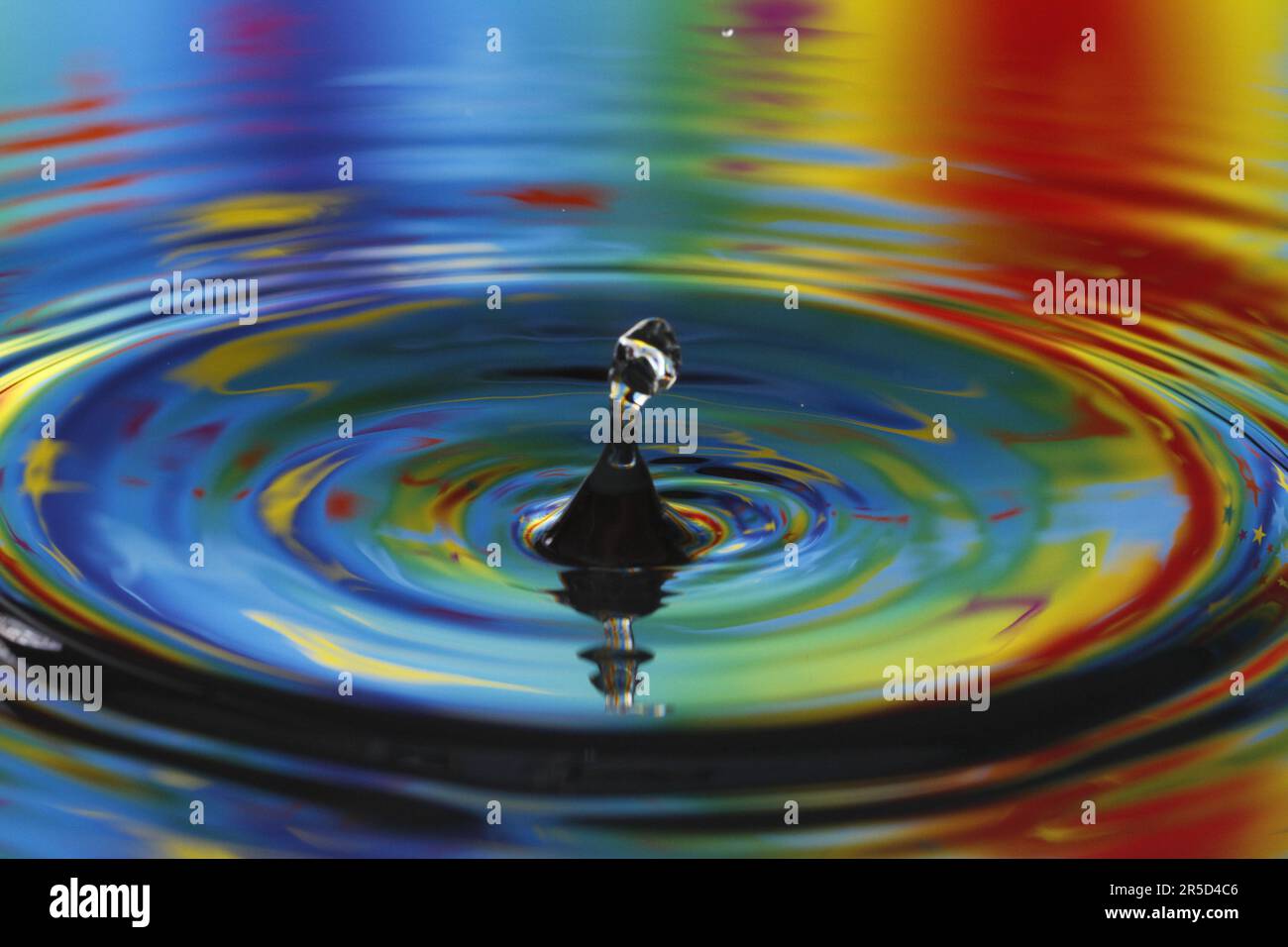 Beautiful water drops splashing on still water Stock Photo - Alamy