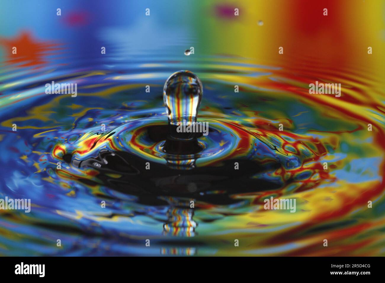 Beautiful water drops splashing on still water Stock Photo - Alamy