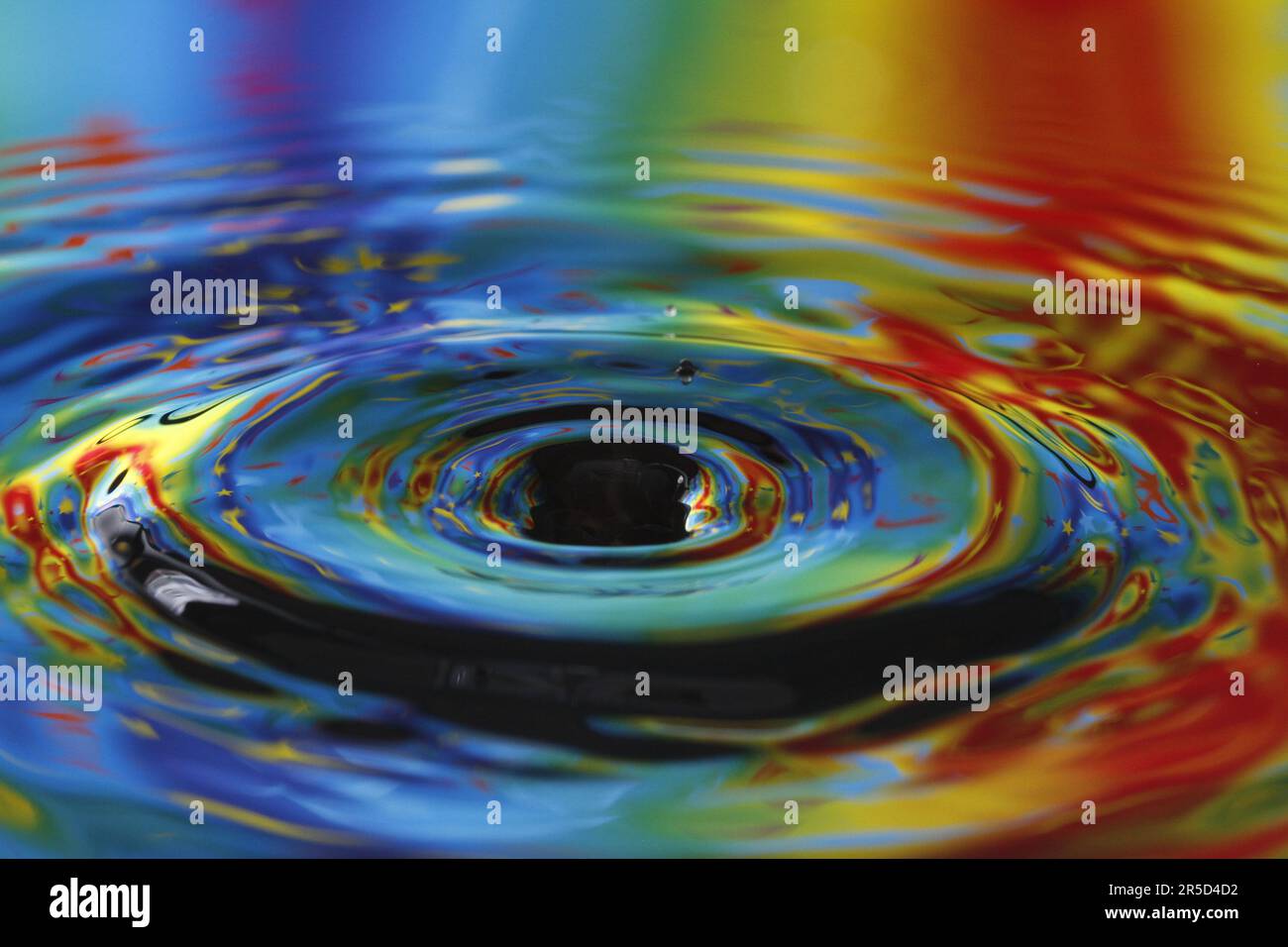 Beautiful water drops splashing on still water Stock Photo - Alamy