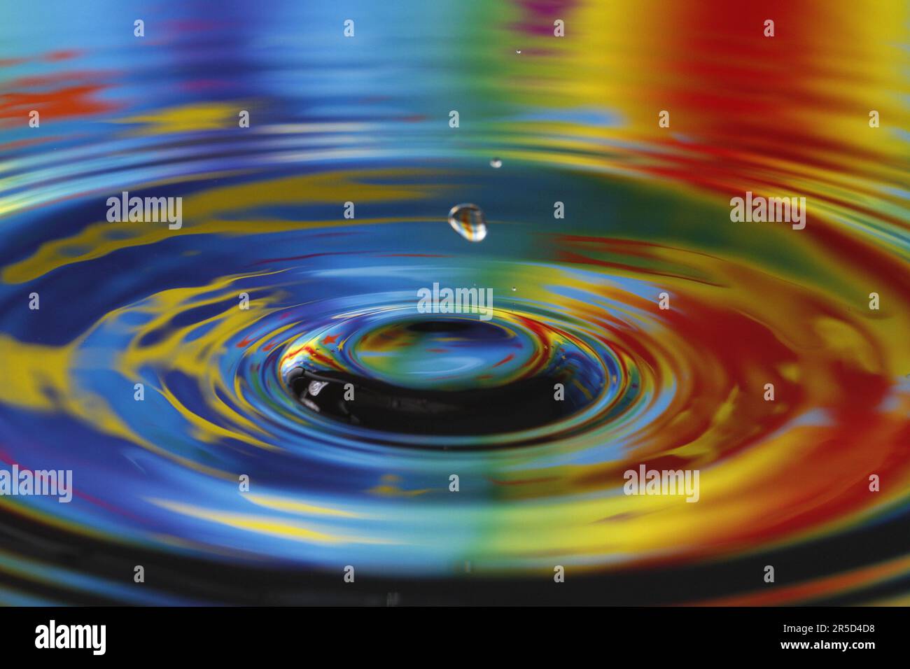Beautiful water drops splashing on still water Stock Photo - Alamy