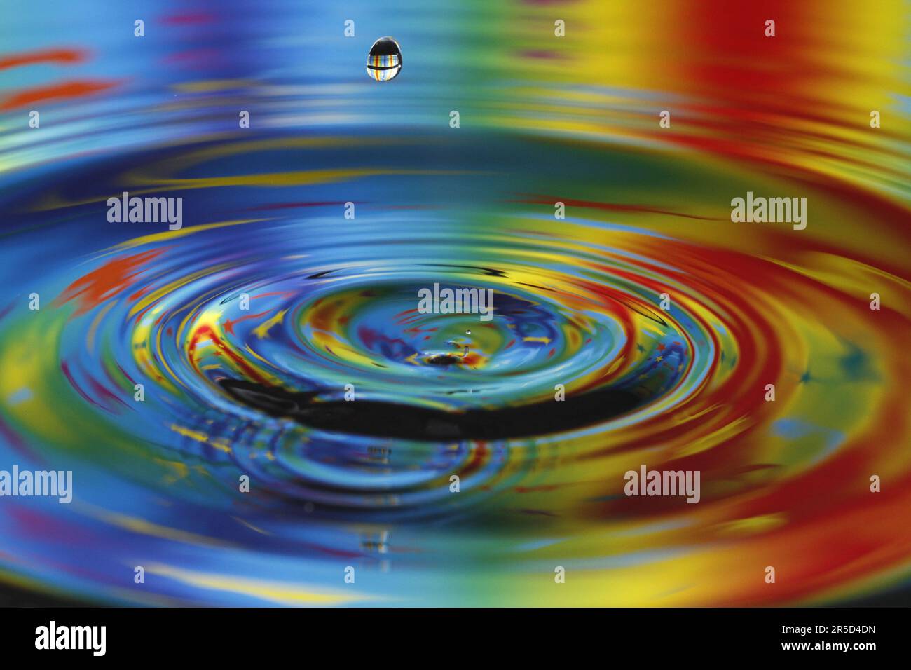 Beautiful water drops splashing on still water Stock Photo - Alamy