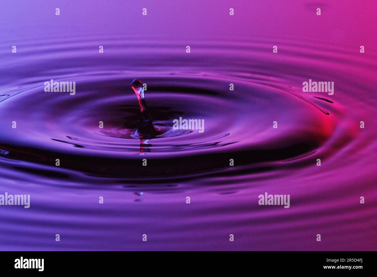 Beautiful water drops splashing on still water Stock Photo - Alamy