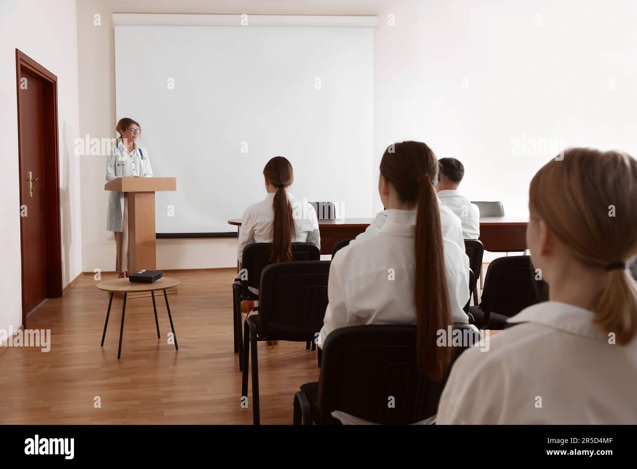 Doctor giving lecture in conference room with projection screen Stock ...