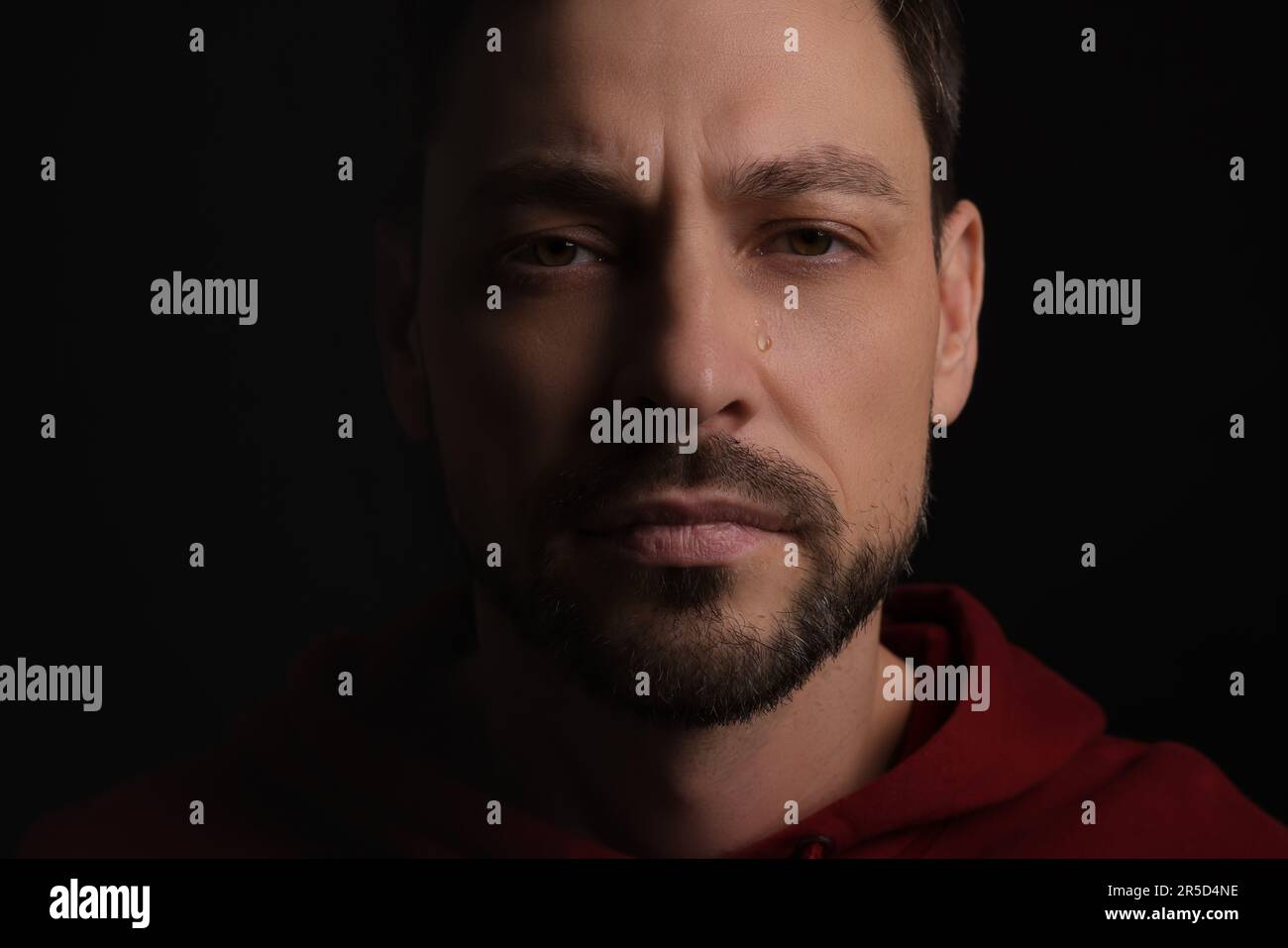 Portrait of sad man on black background Stock Photo - Alamy