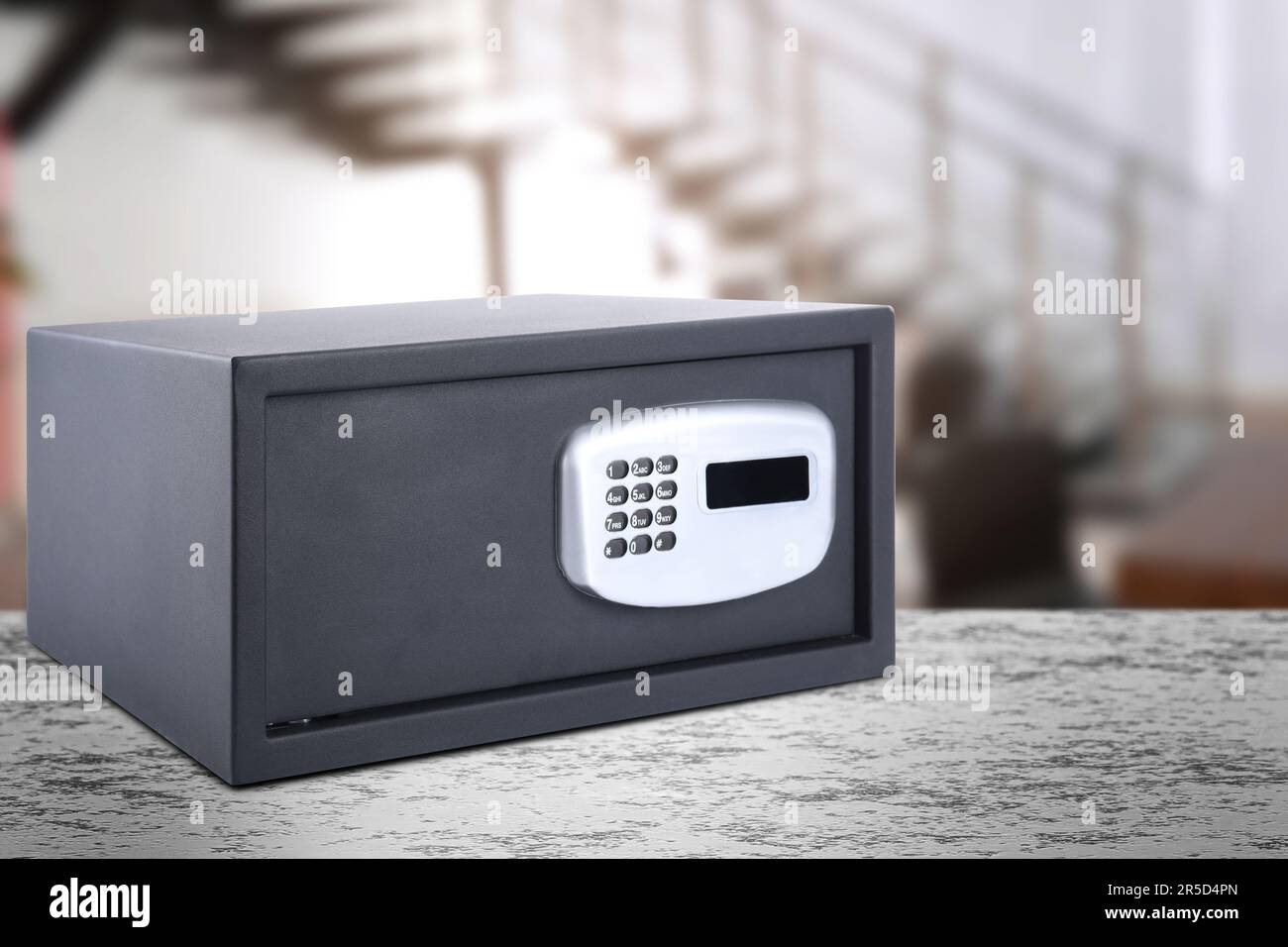 Closed steel safe with electronic lock on light grey table indoors ...