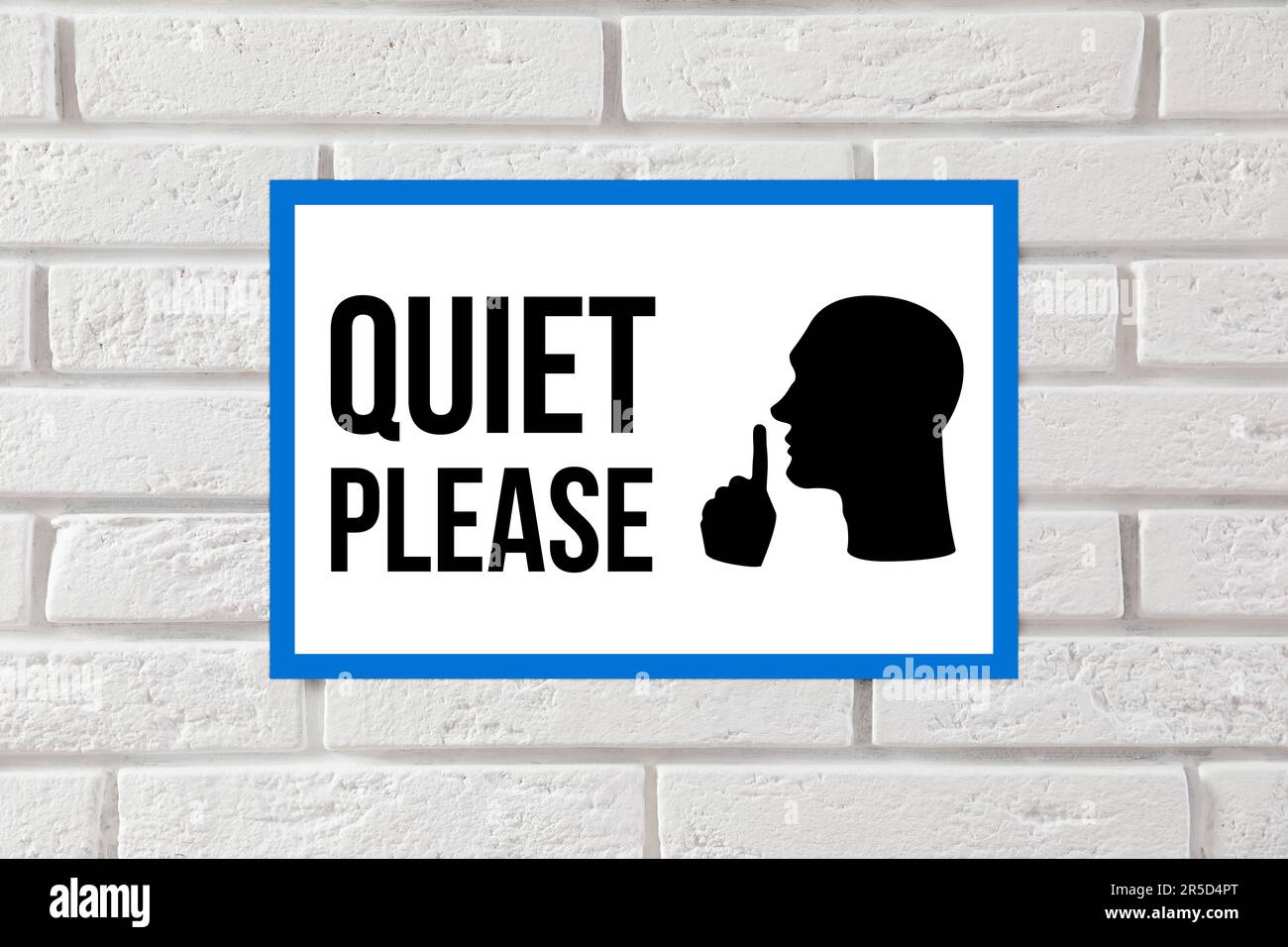 Quiet Please sign with shush gesture image on white brick wall Stock ...