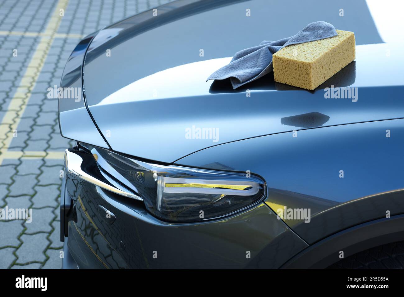 Sponge and rag on car hood outdoors. Cleaning products Stock Photo - Alamy