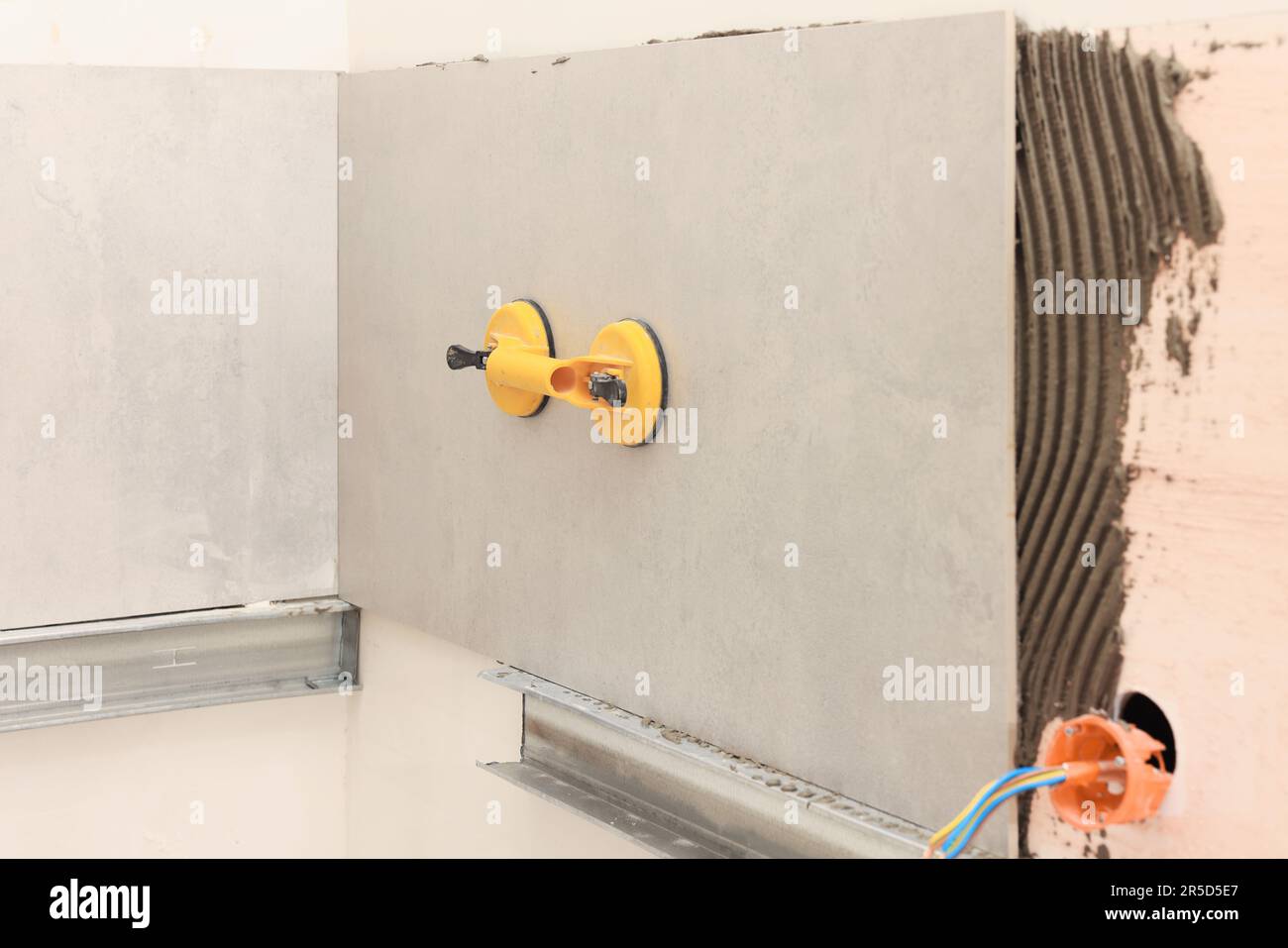 Yellow suction plate attached to tile on wall Stock Photo - Alamy