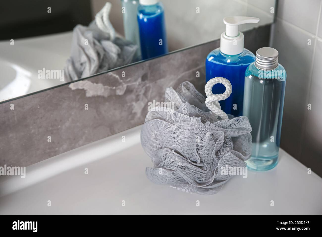 Grey shower puff and cosmetic products on washbasin in bathroom Stock ...