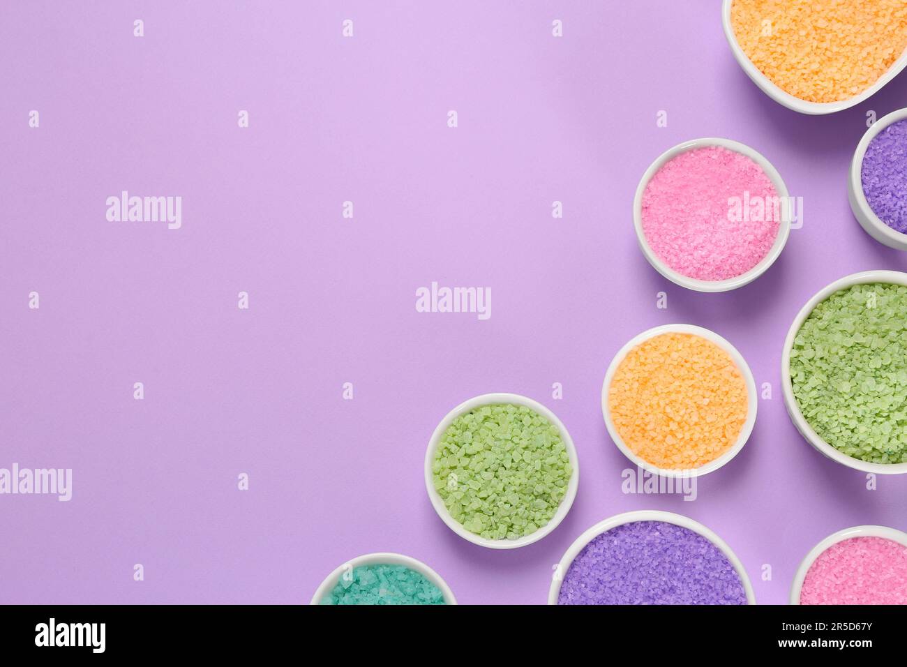Different types of aromatic sea salt on purple background, flat lay ...