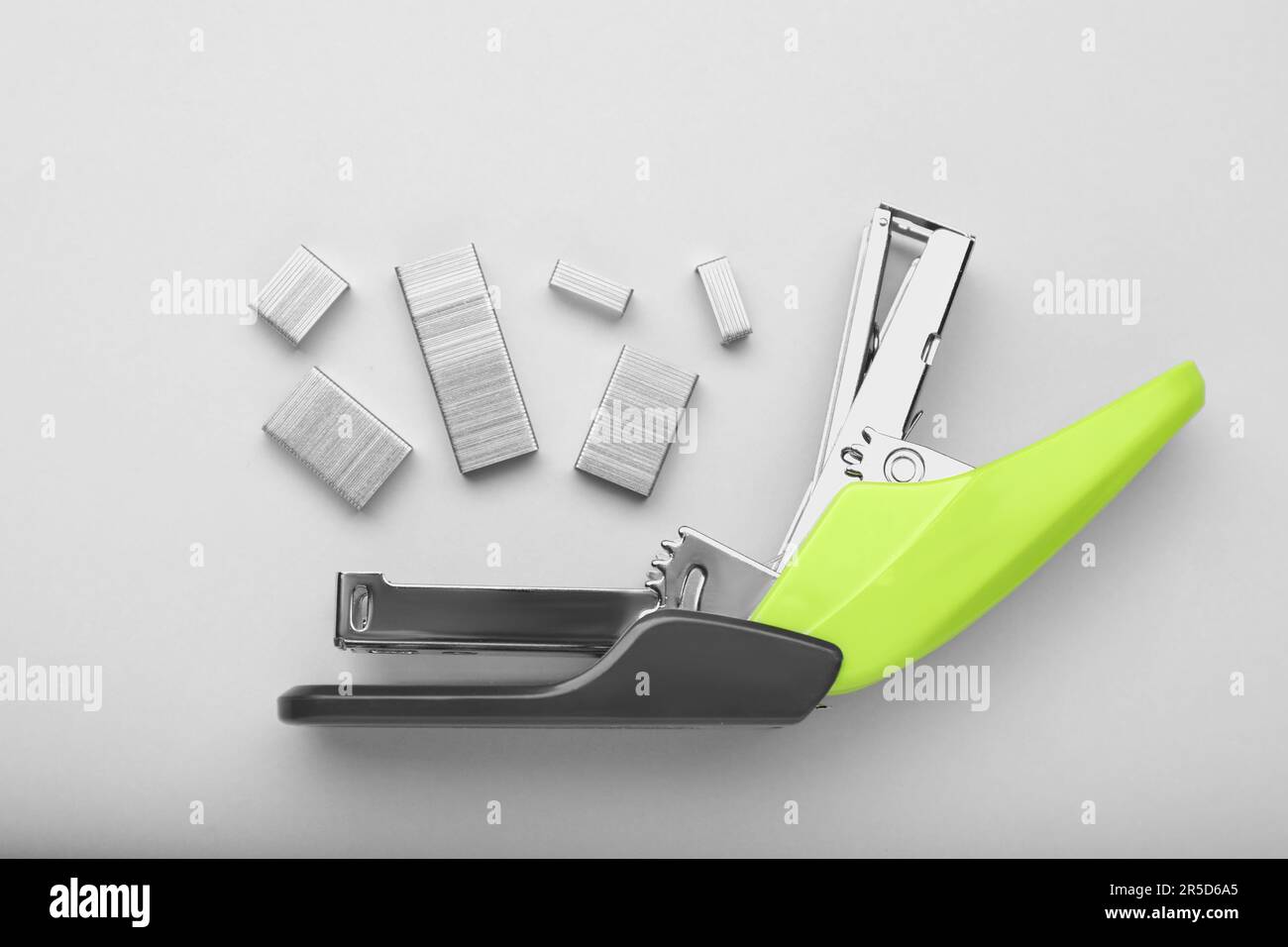 New bright stapler with staples on white background, fat lay. School ...