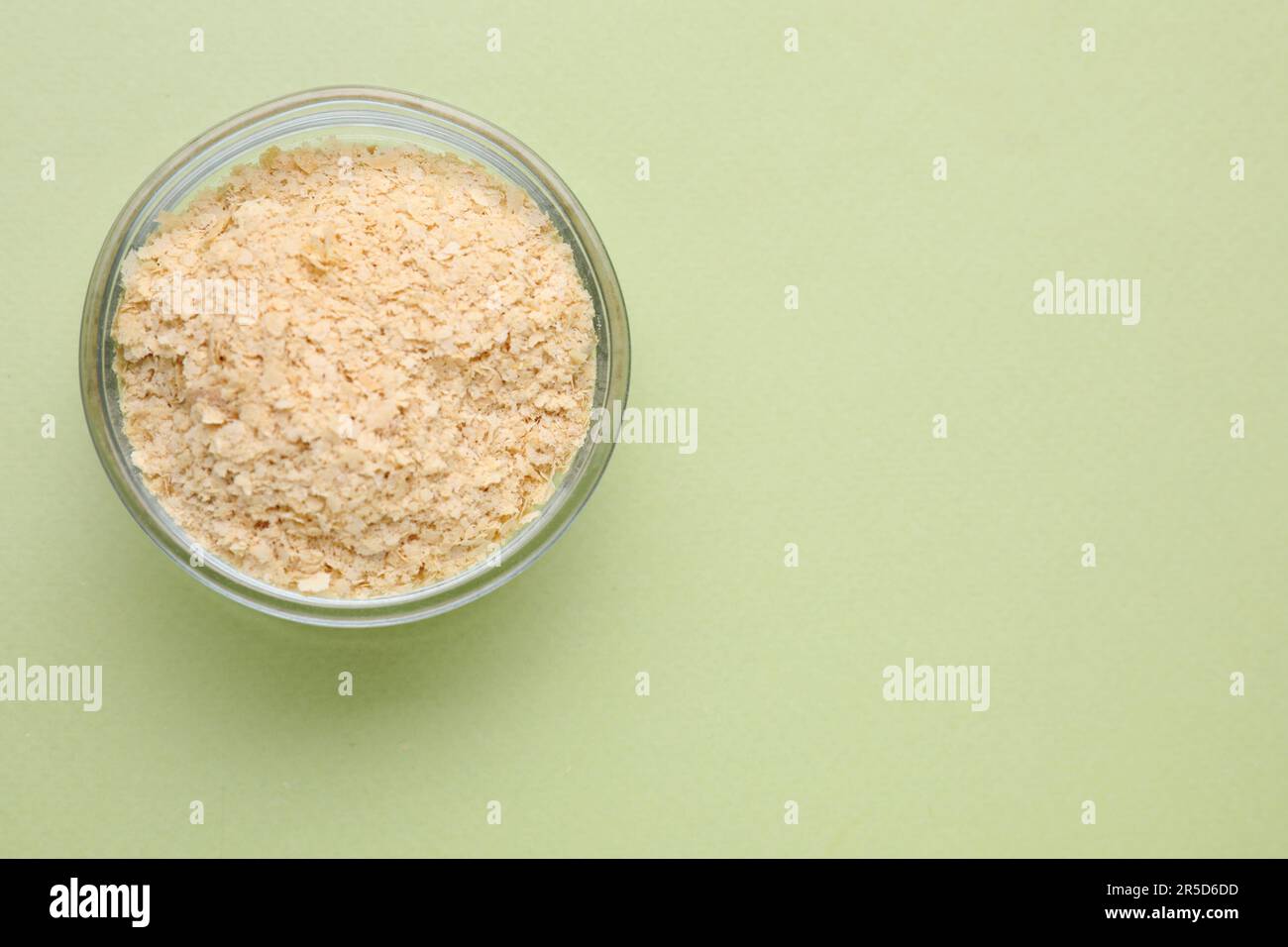 Beer yeast flakes on light green background, top view. Space for text ...
