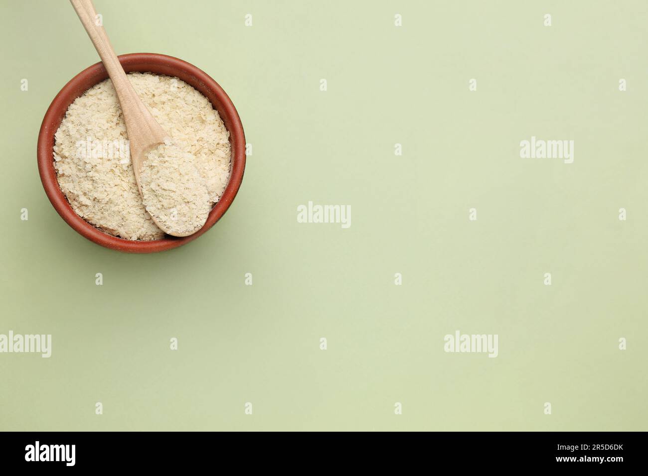 Beer yeast flakes on light green background, top view. Space for text ...
