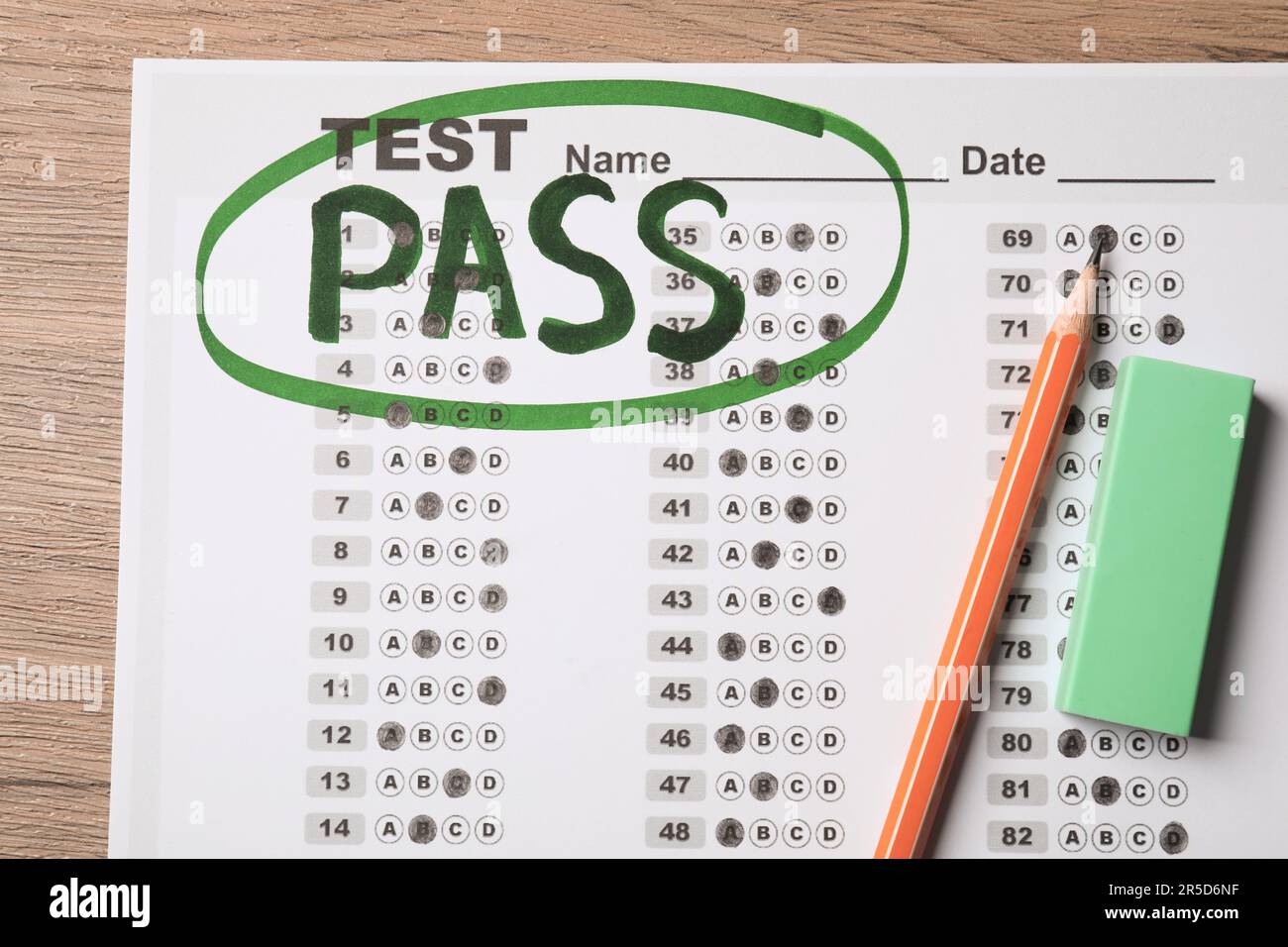 Answer sheet with word Pass, eraser and pencil on wooden table, flat ...