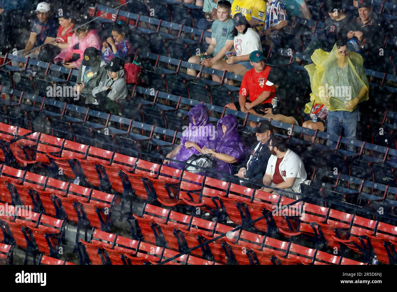 Fans take shelter during a rain delay before a baseball game between ...