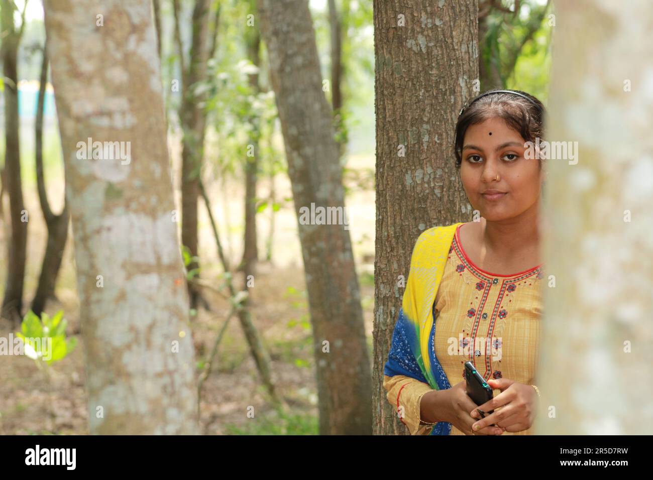 Close-up portrait of a Indian teenage girl looking at camera over ...