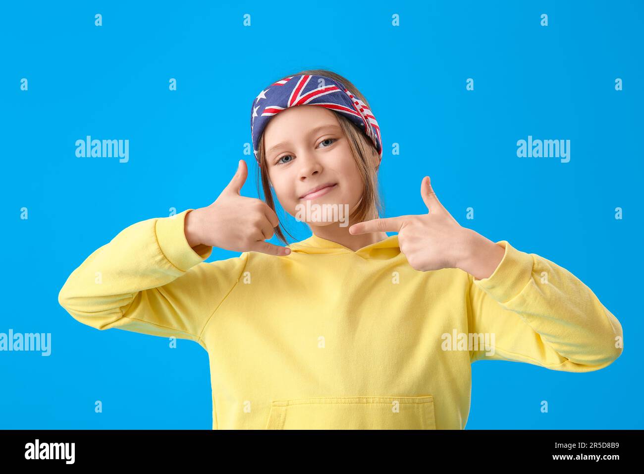 Little girl showing "call me" gesture on blue background Stock Photo ...