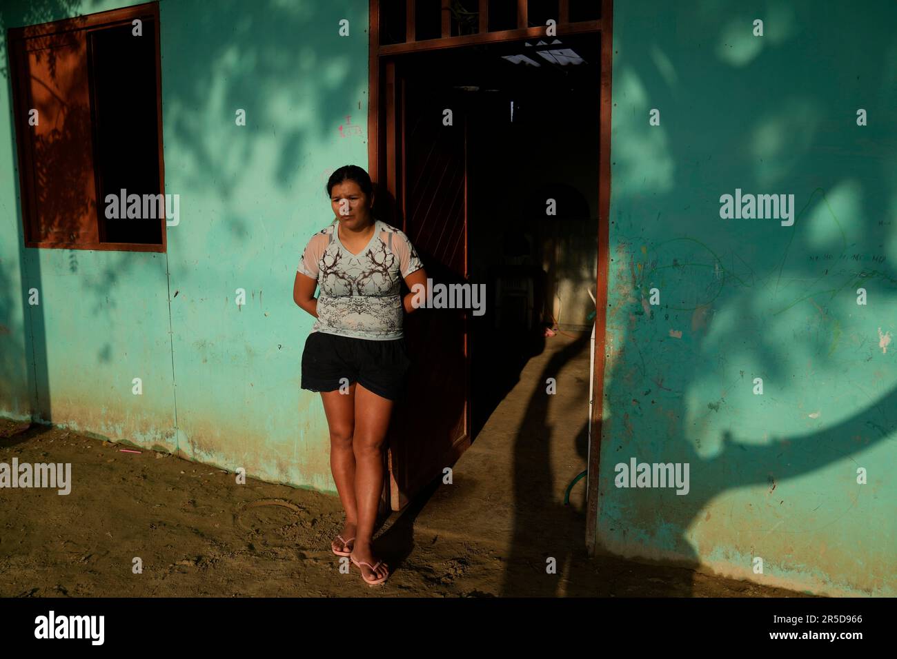 Dengue patient Ybis Flores stands in the doorway of her home at the Los ...